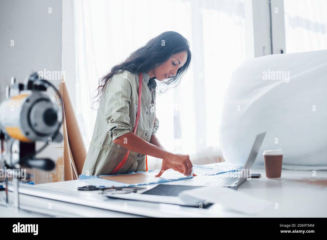 Busy with cloth. Beautiful female worker is in the sewing factory Stock ...