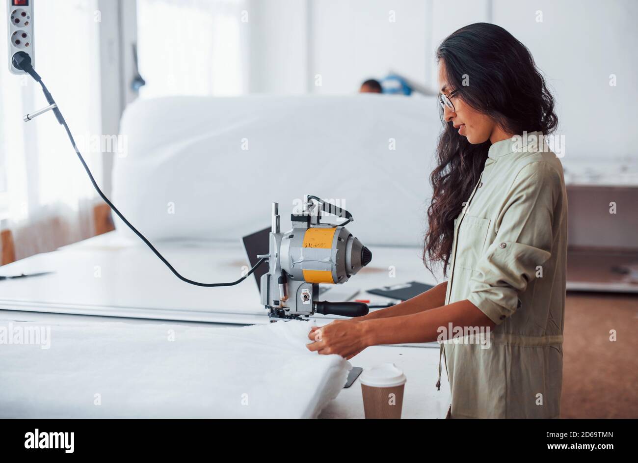 Beautiful female worker with glasses is in the sewing factory Stock ...