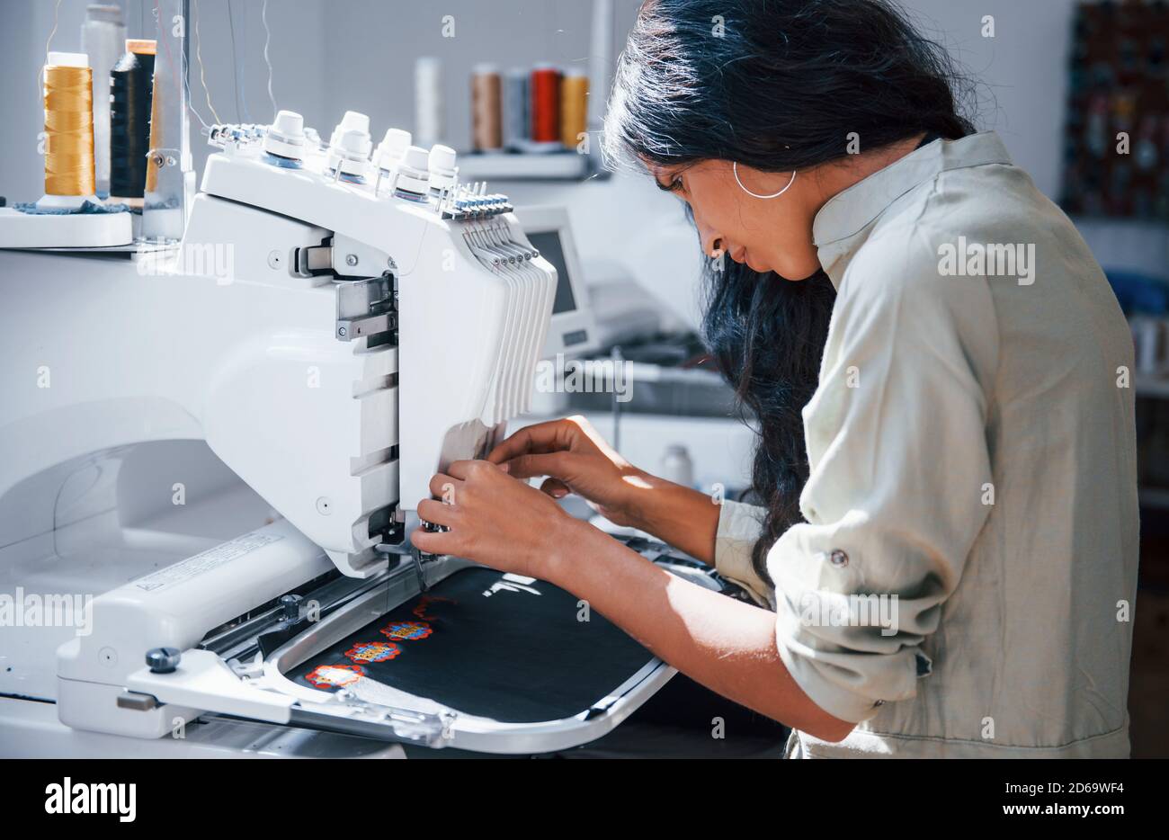 Beautiful female worker is in the sewing factory by the machine Stock ...