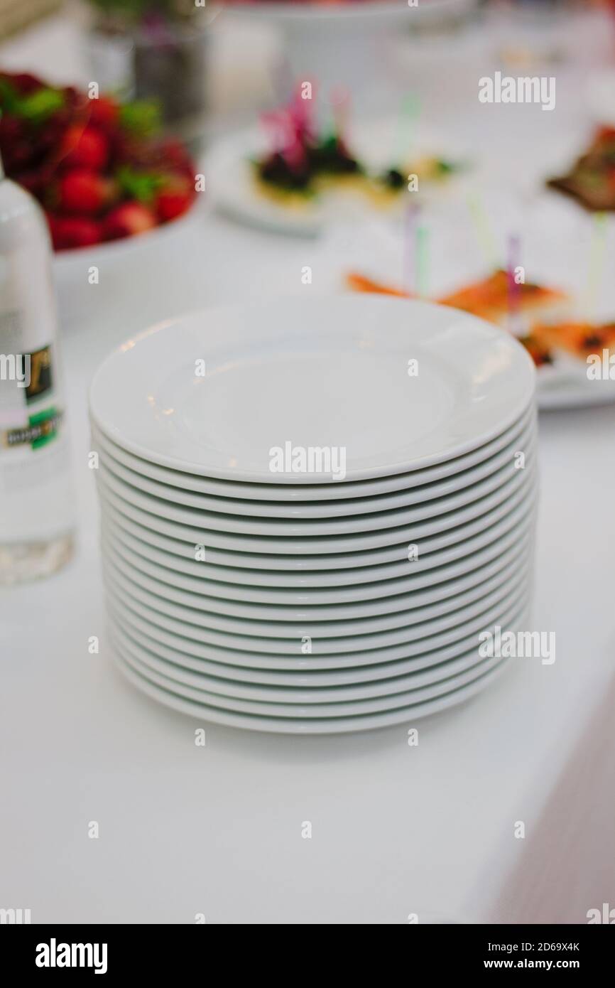 Pile of white plates on catering buffet Stock Photo - Alamy
