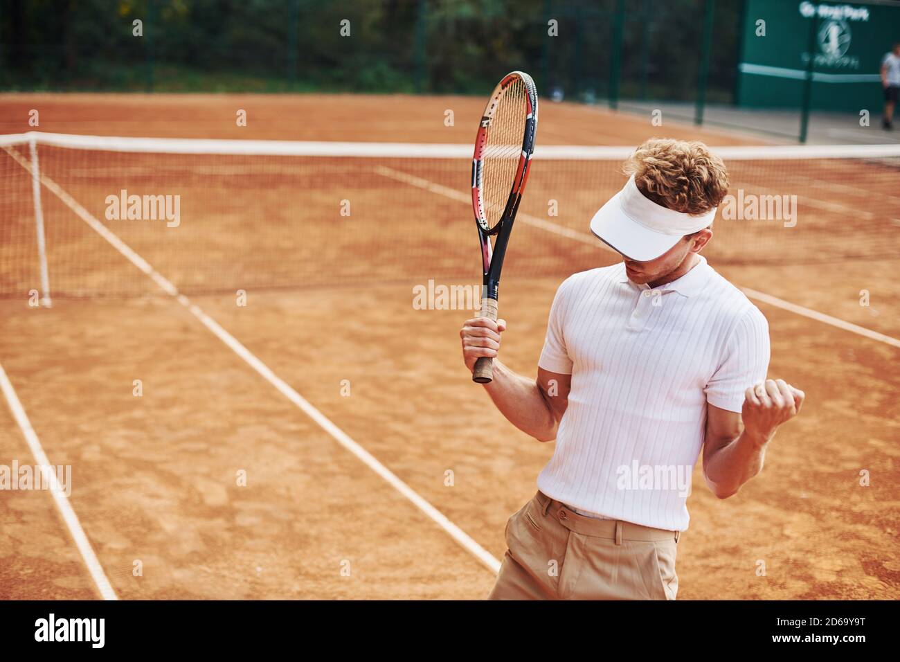 Celebrating victory. Young tennis player in sportive clothes is on the ...