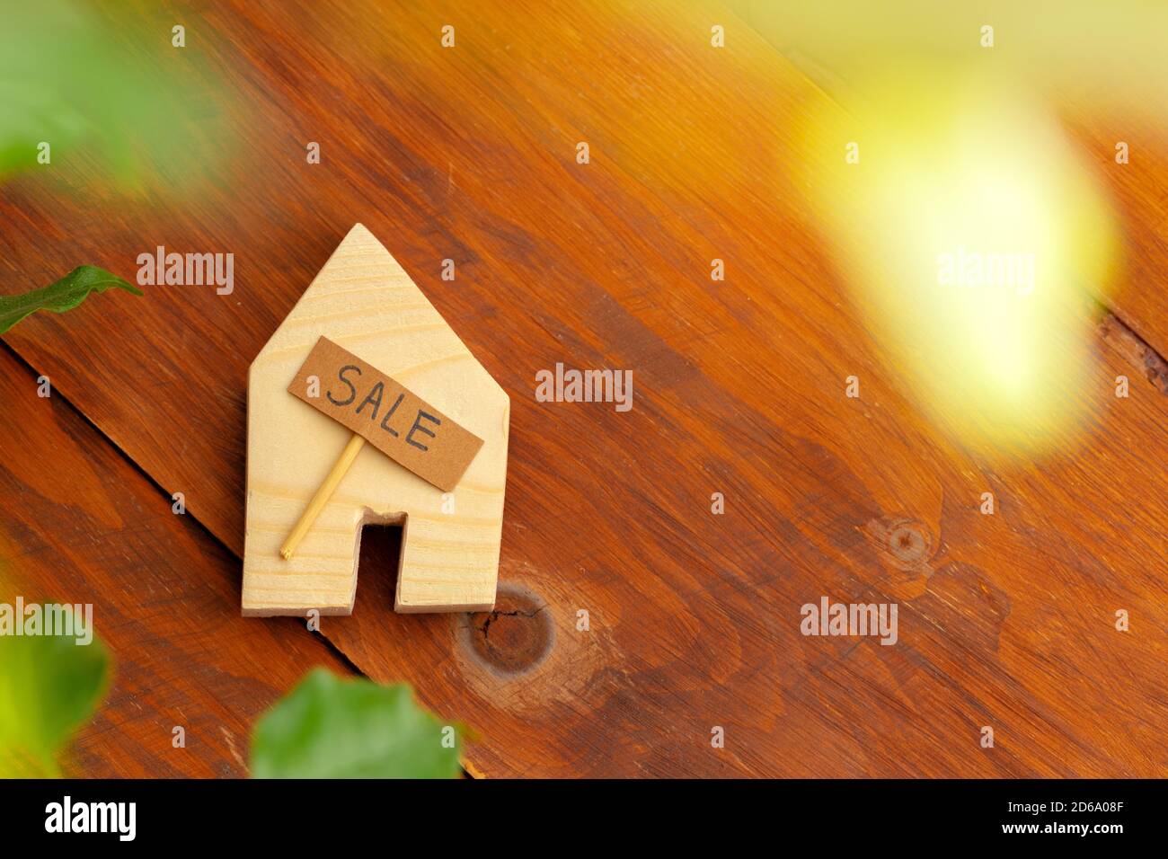 Wooden house model and for sale sign Stock Photo - Alamy