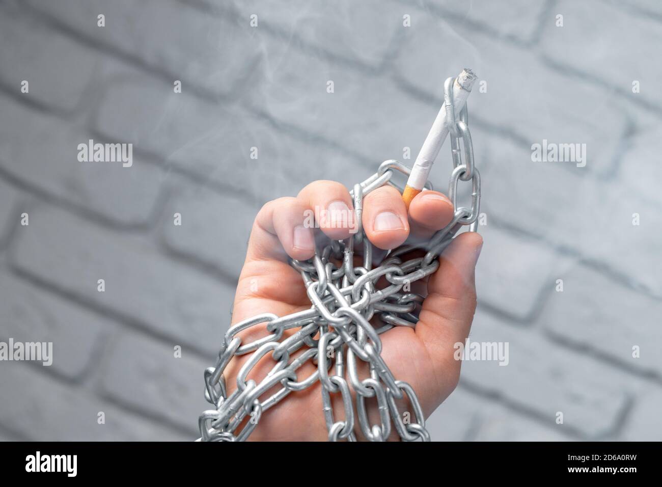 Male hand in metal chains holding cigarette Stock Photo - Alamy