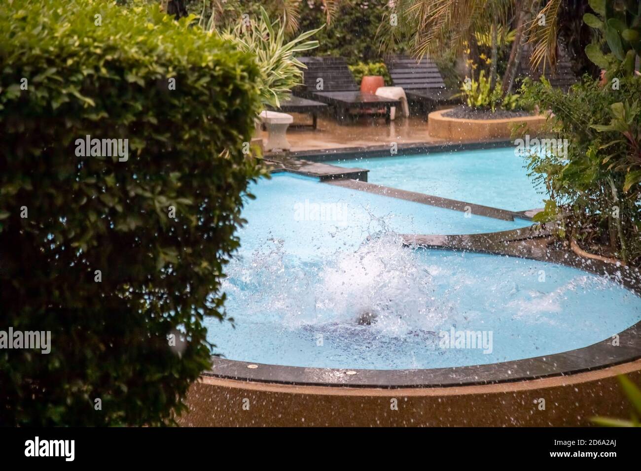 splash of water after jumping into a tropical outdoor pool in the ...