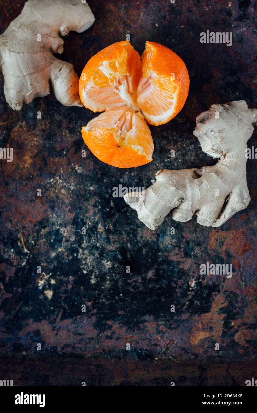 Ginger root with orange on black rustic surface Stock Photo - Alamy