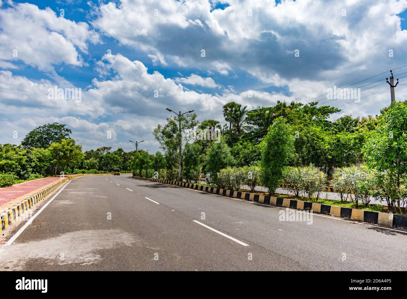 straight road of national highway with trees plantation on center of ...
