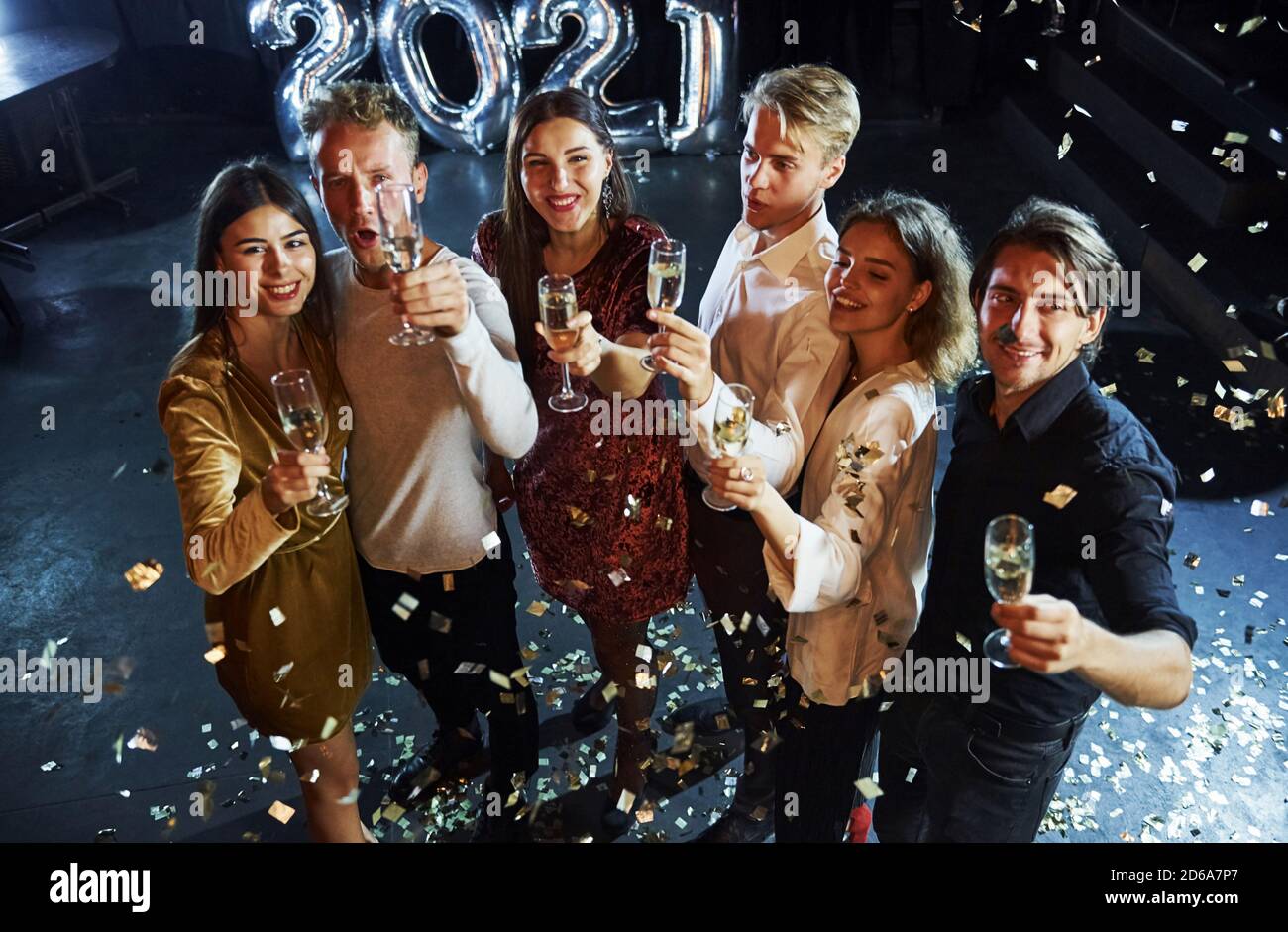 Cheerful group of people with drinks in hands celebrating new 2021 year ...