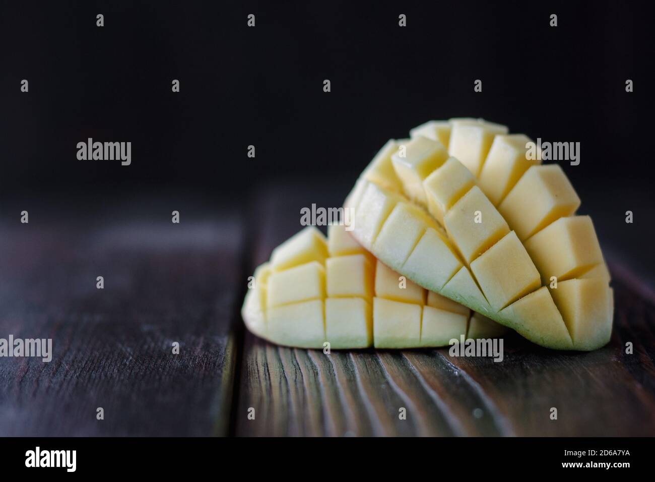 Mango halves. Two pieces of fresh mango fruit over wooden table Stock ...