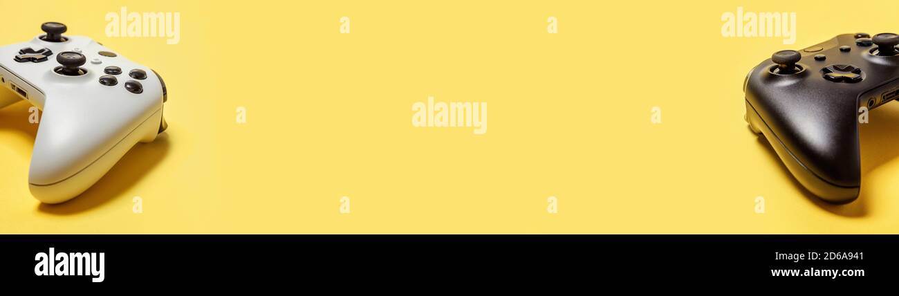 White and black two joystick gamepad, game console isolated on yellow ...