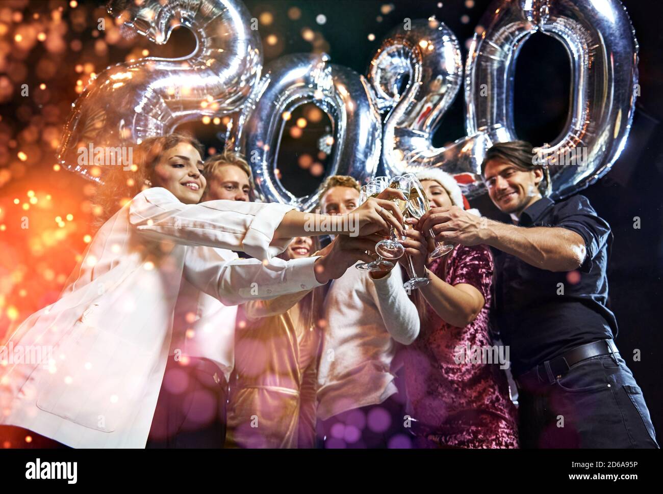Positive young people holds balloons with new 2020 year and celebrating ...