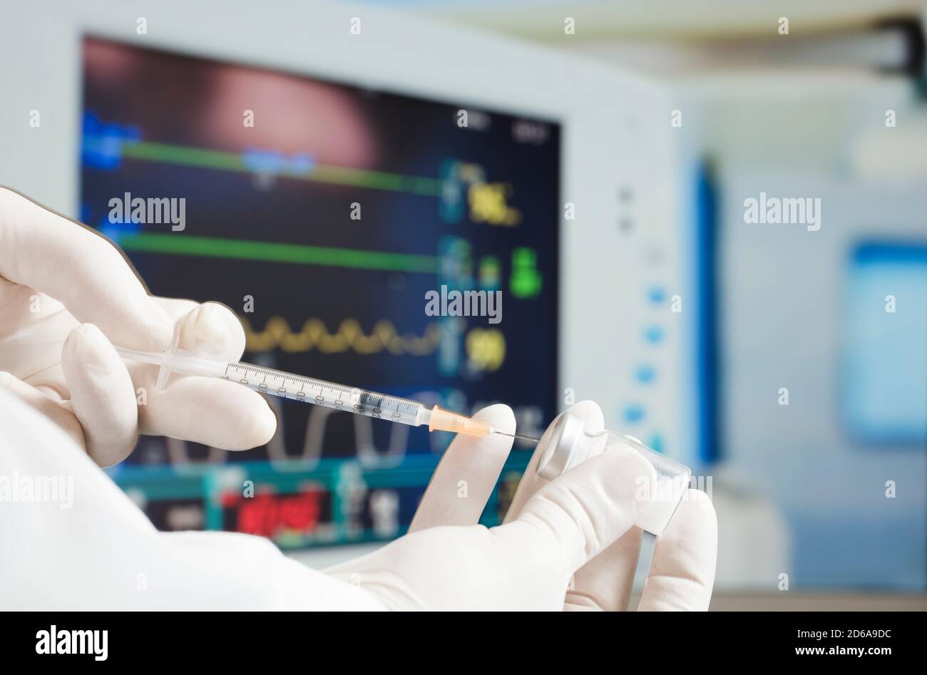 Syringe in the doctor's hand, (focus on orange needle cannula) hospital ...