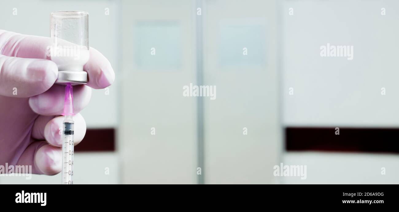 Syringe in the doctor's hand, (focus on orange needle cannula) hospital ...
