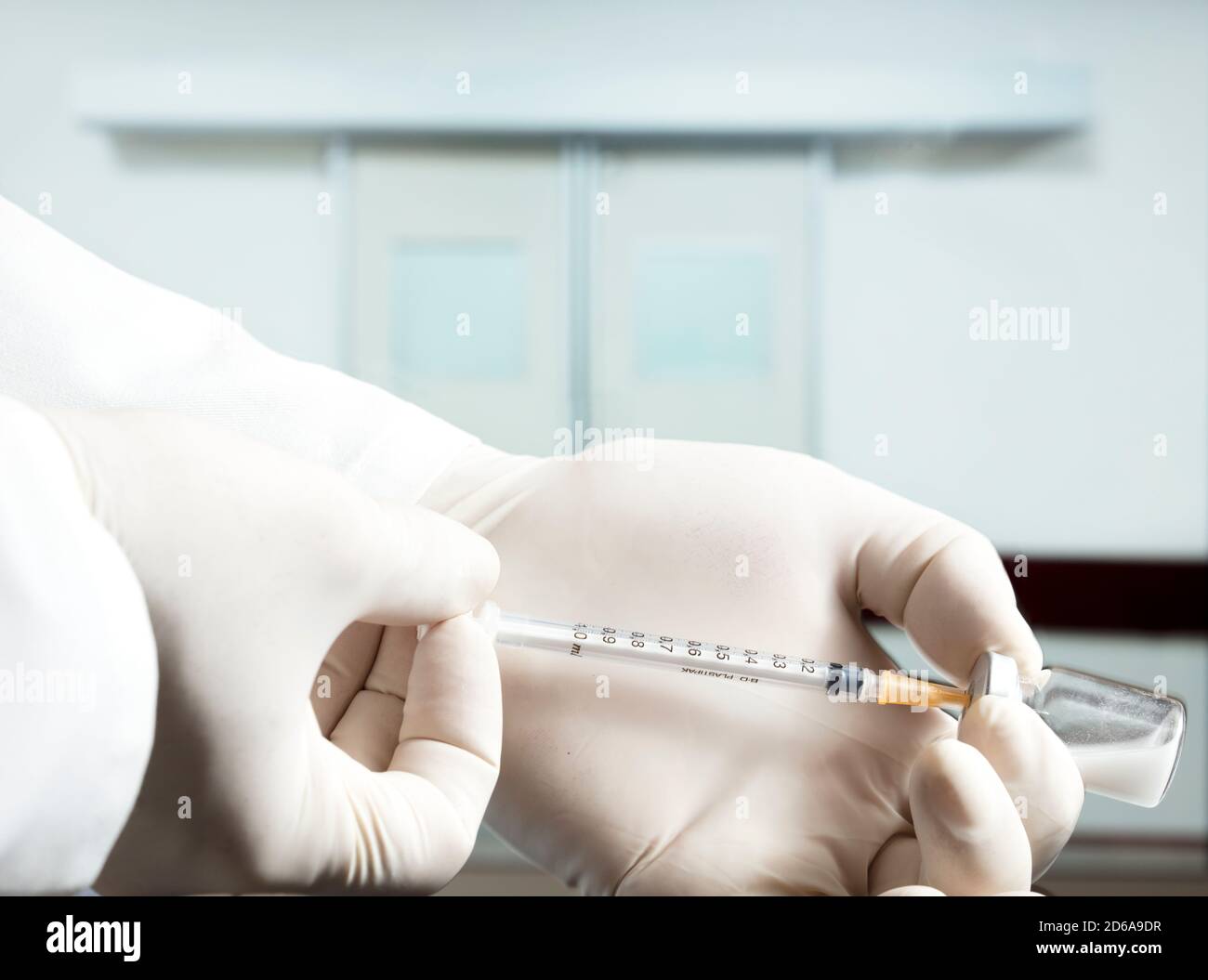 Syringe in the doctor's hand, (focus on orange needle cannula) hospital ...