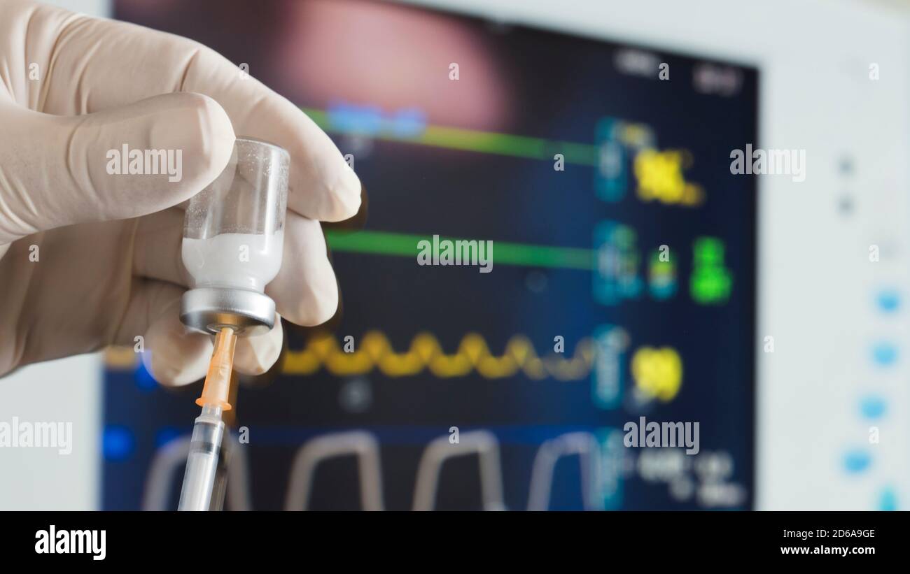 Syringe in the doctor's hand, (focus on orange needle cannula) hospital ...