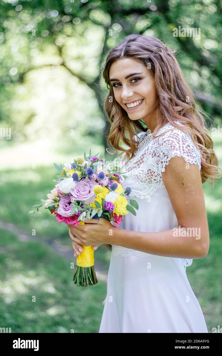 Wedding scene - bride with flower bouquet outdoor Stock Photo - Alamy