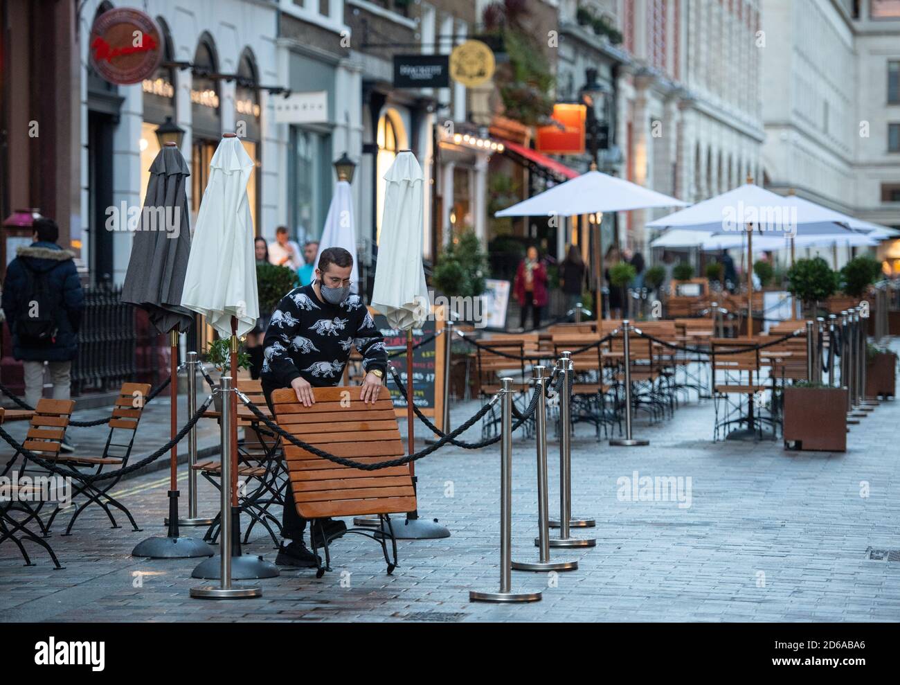 Man packs away tables chairs outside bar in covent garden hi-res stock ...