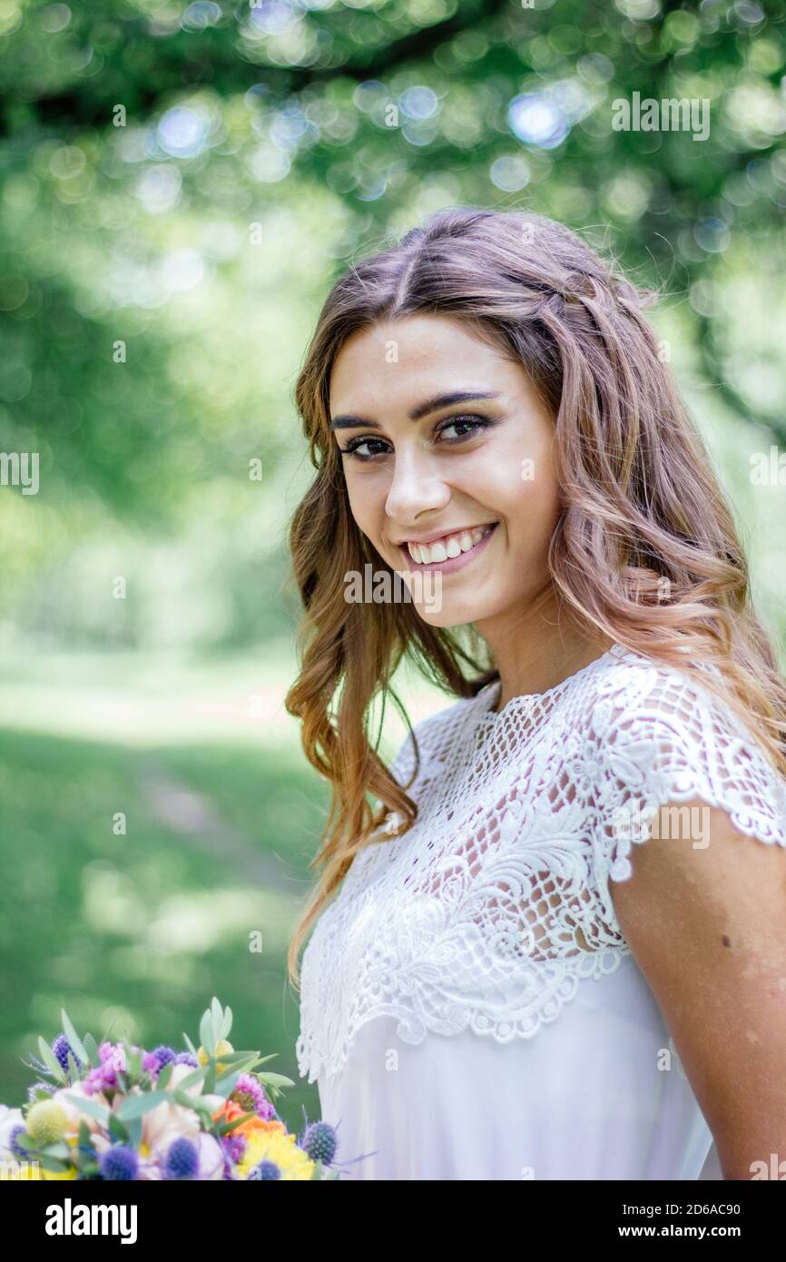 Wedding scene - bride with flower bouquet outdoor Stock Photo - Alamy