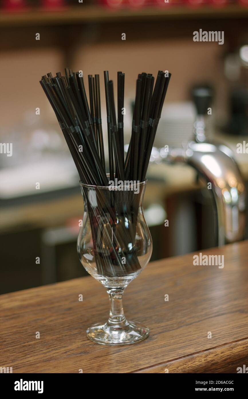 Black cocktail tubes in a transparent glass on bar Stock Photo - Alamy