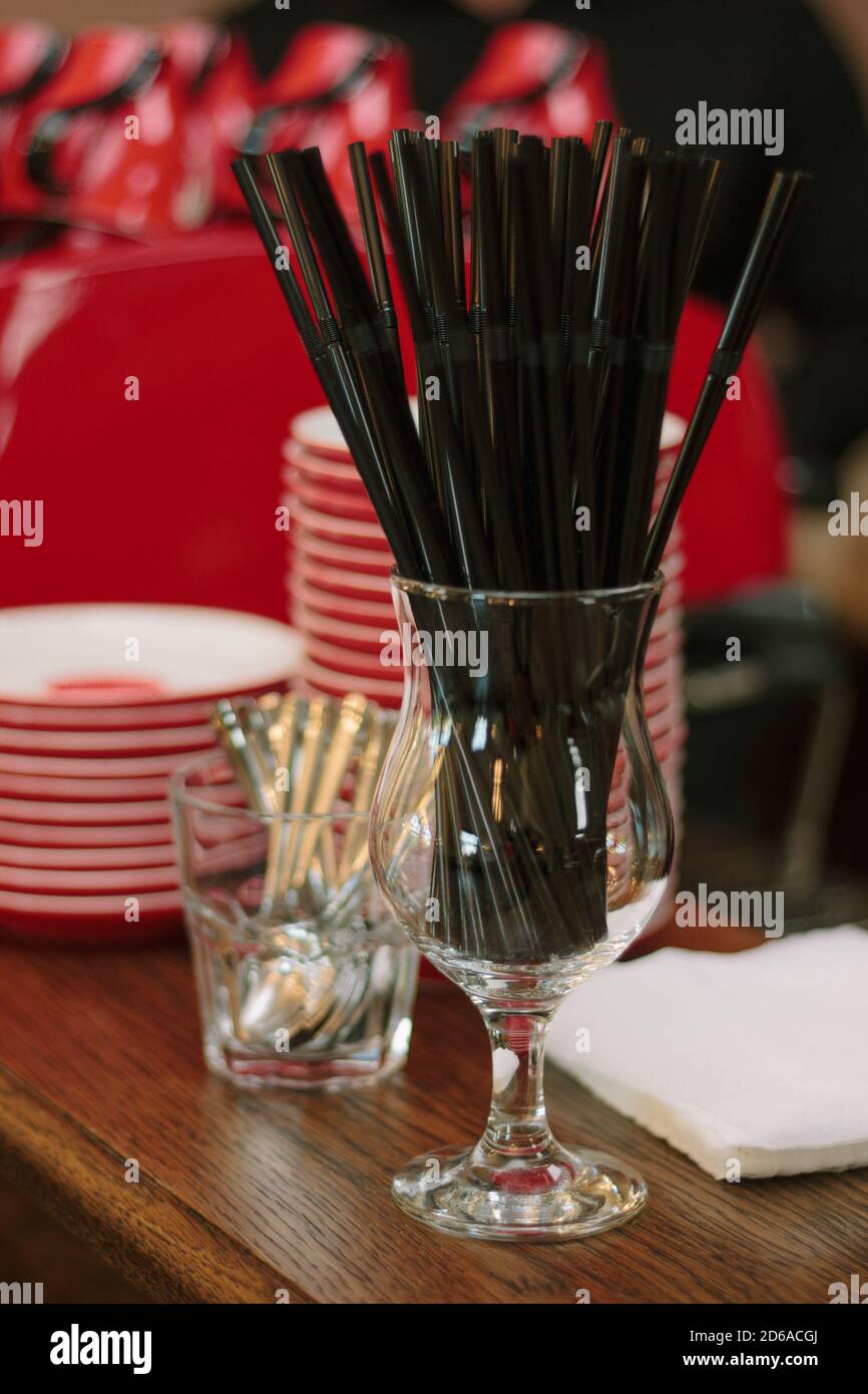 Black cocktail tubes in a transparent glass on bar Stock Photo - Alamy