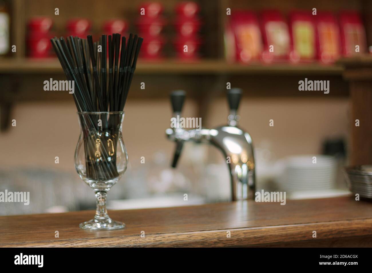 Black cocktail tubes in a transparent glass on bar Stock Photo - Alamy