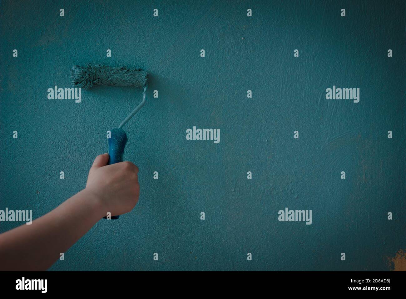 Painting wall by aqua color paints with paint roll Stock Photo - Alamy