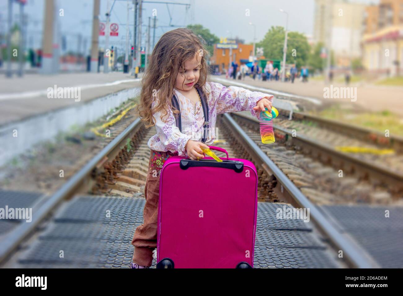 Little girl stay on the rails on railway station Stock Photo - Alamy