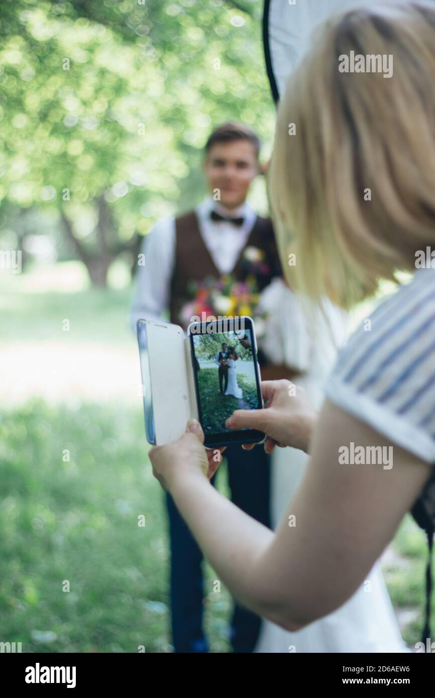 Photographing a wedding couple by the smartphone Stock Photo - Alamy
