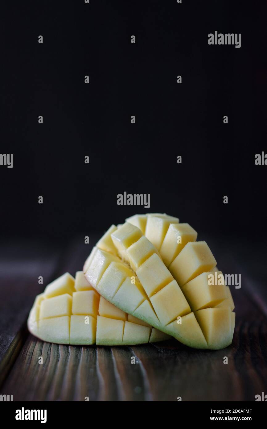 Mango halves. Two pieces of fresh mango fruit over wooden table Stock ...