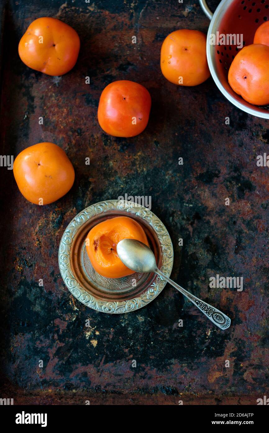 Persimmon ready to eat on silver plate and spoon Stock Photo - Alamy