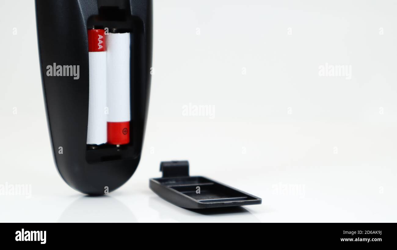 Black TV remote control with AAA alkaline batteries in red and white on ...