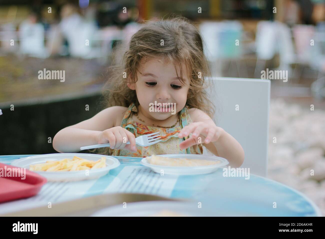 Little kid girl eating at the fast food restaurant Stock Photo - Alamy
