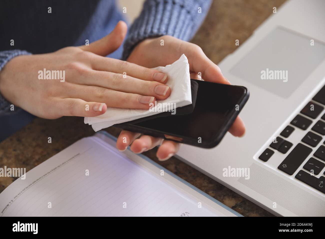 Mid section of woman wiping her smartphone with a tissue Stock Photo ...
