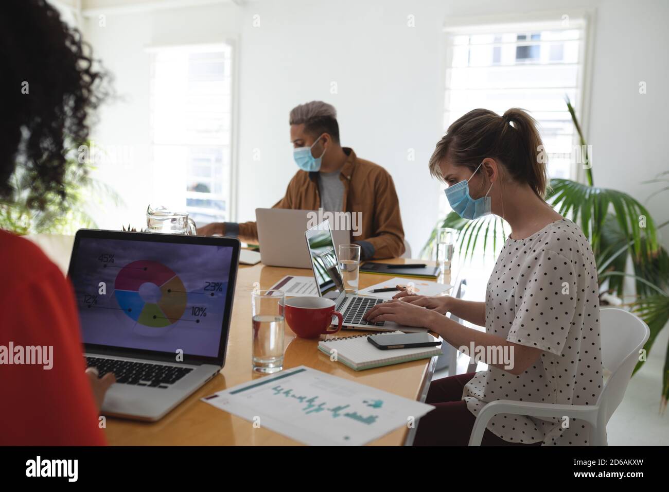Office colleagues wearing face mask working at office Stock Photo - Alamy