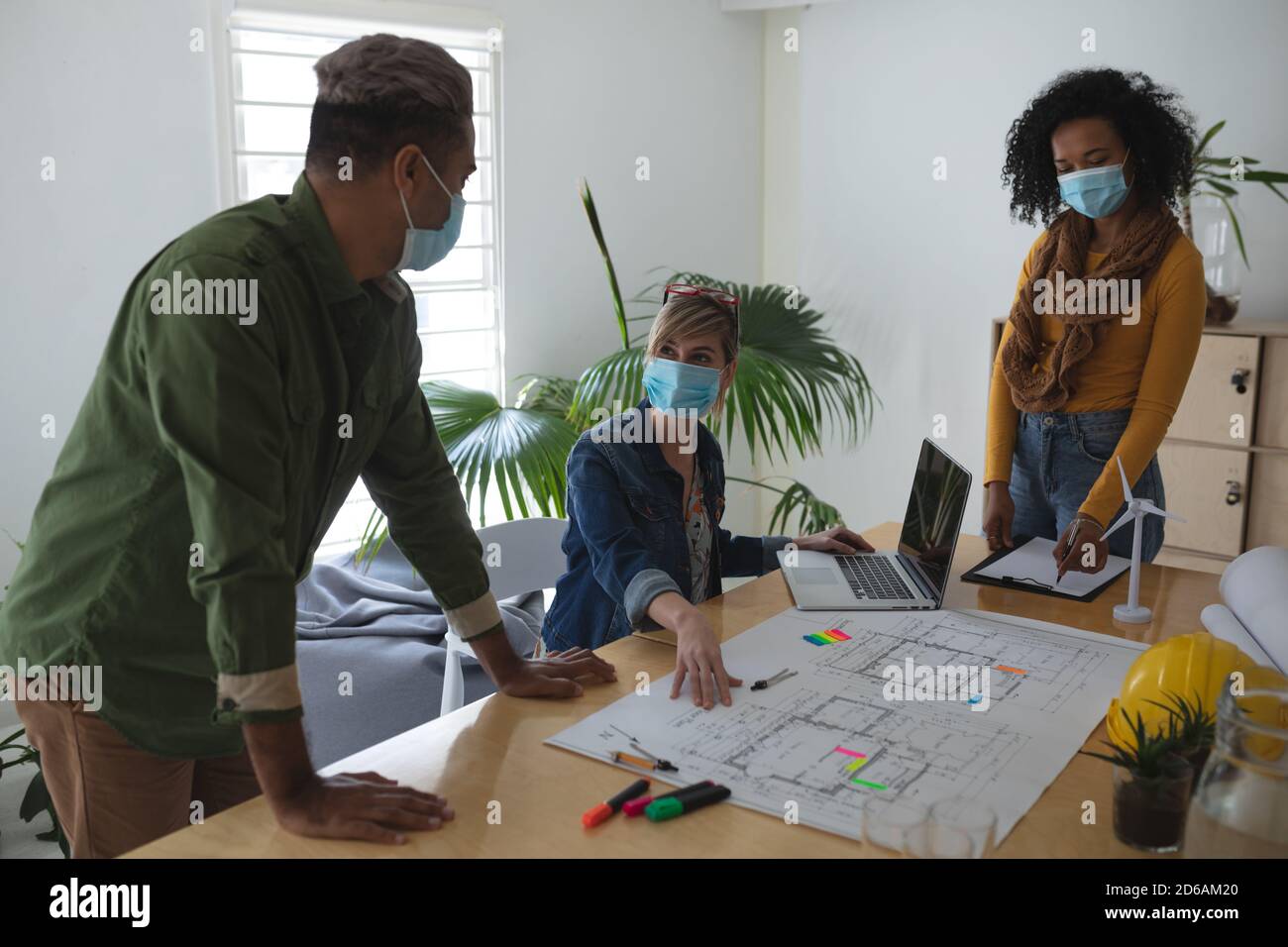 Office colleagues wearing face mask discussing in meeting room at ...