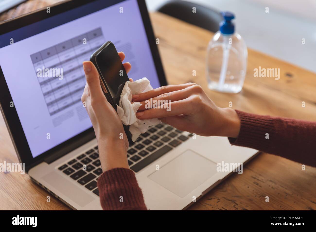Mid section of woman wiping her smartphone with a tissue Stock Photo ...