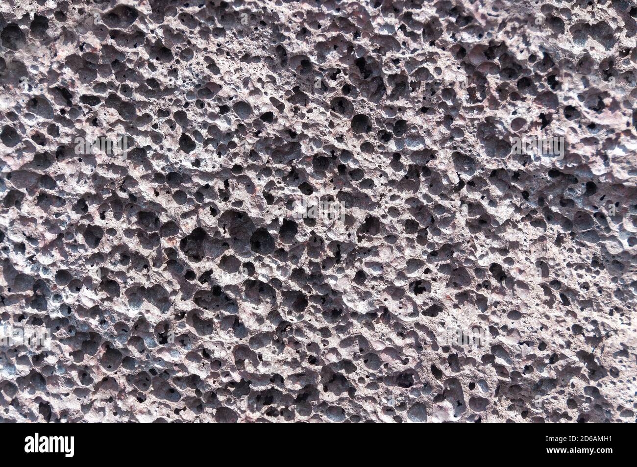 Close up of grey, deeply pitted volcanic rock on the big island of ...