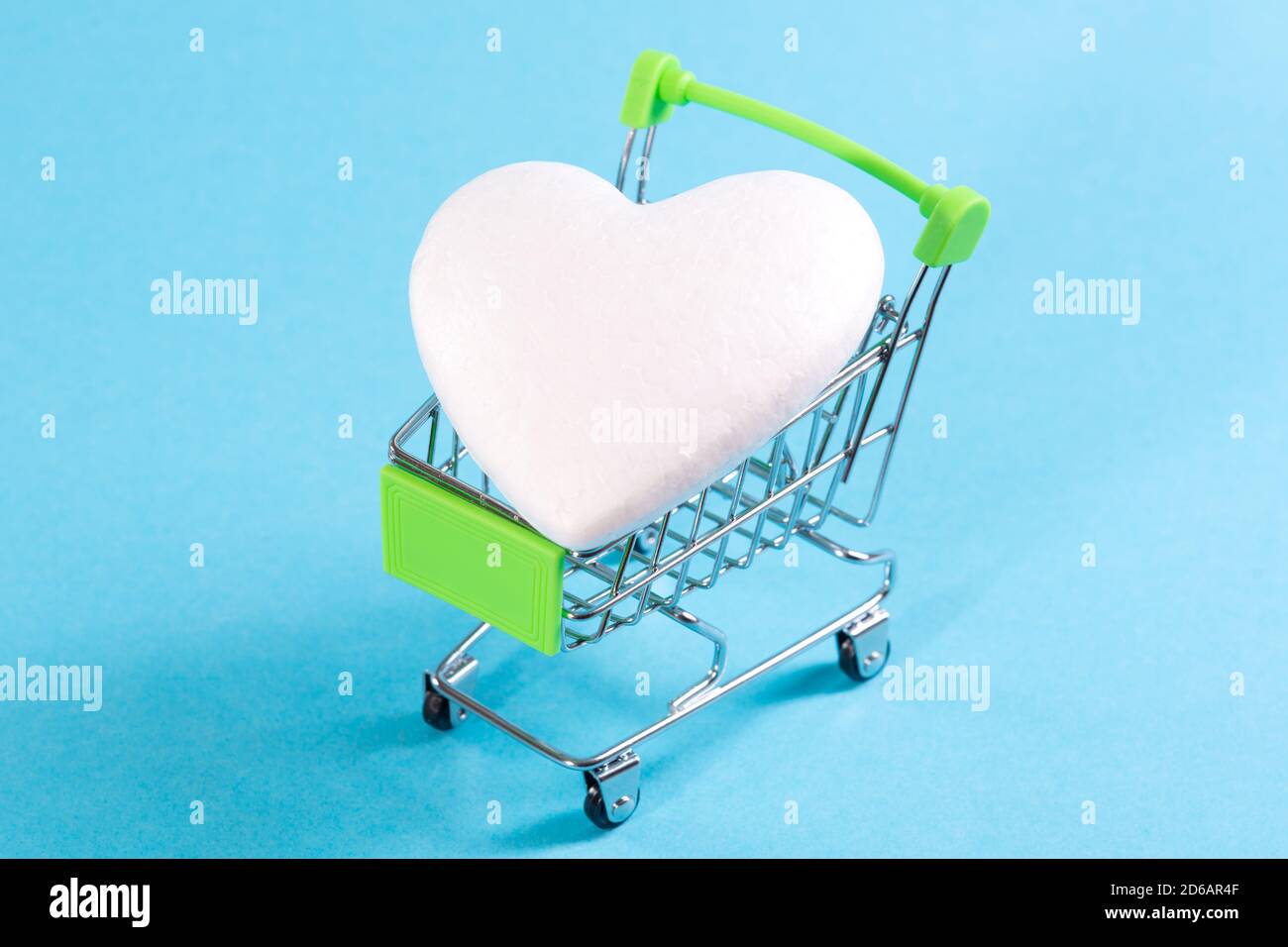 White heart in shopping baskets on a blue background. Buy love, buy a ...