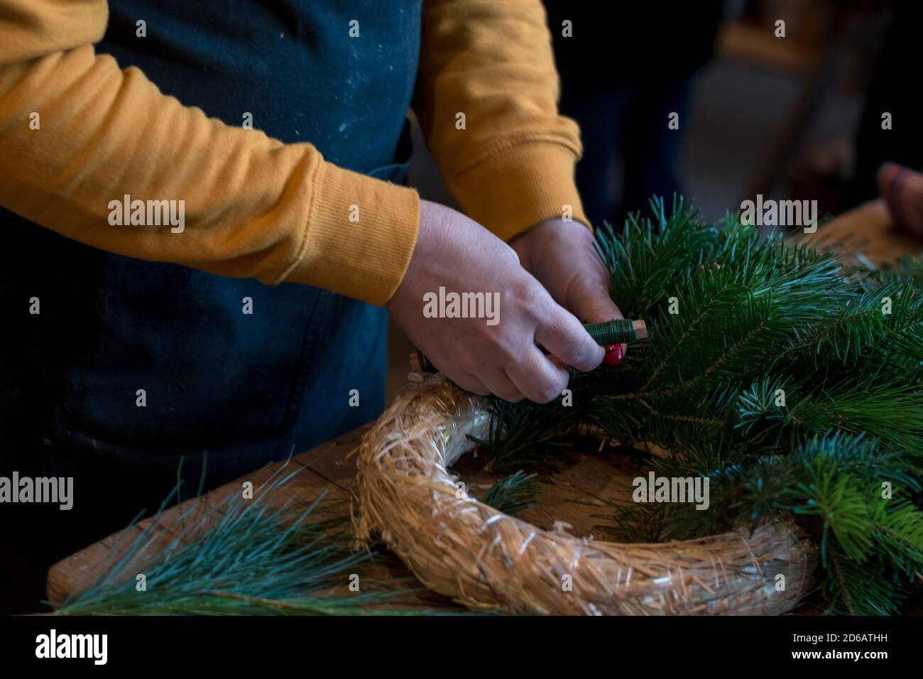 straw round base, scissors and green twigs components in human hands in ...