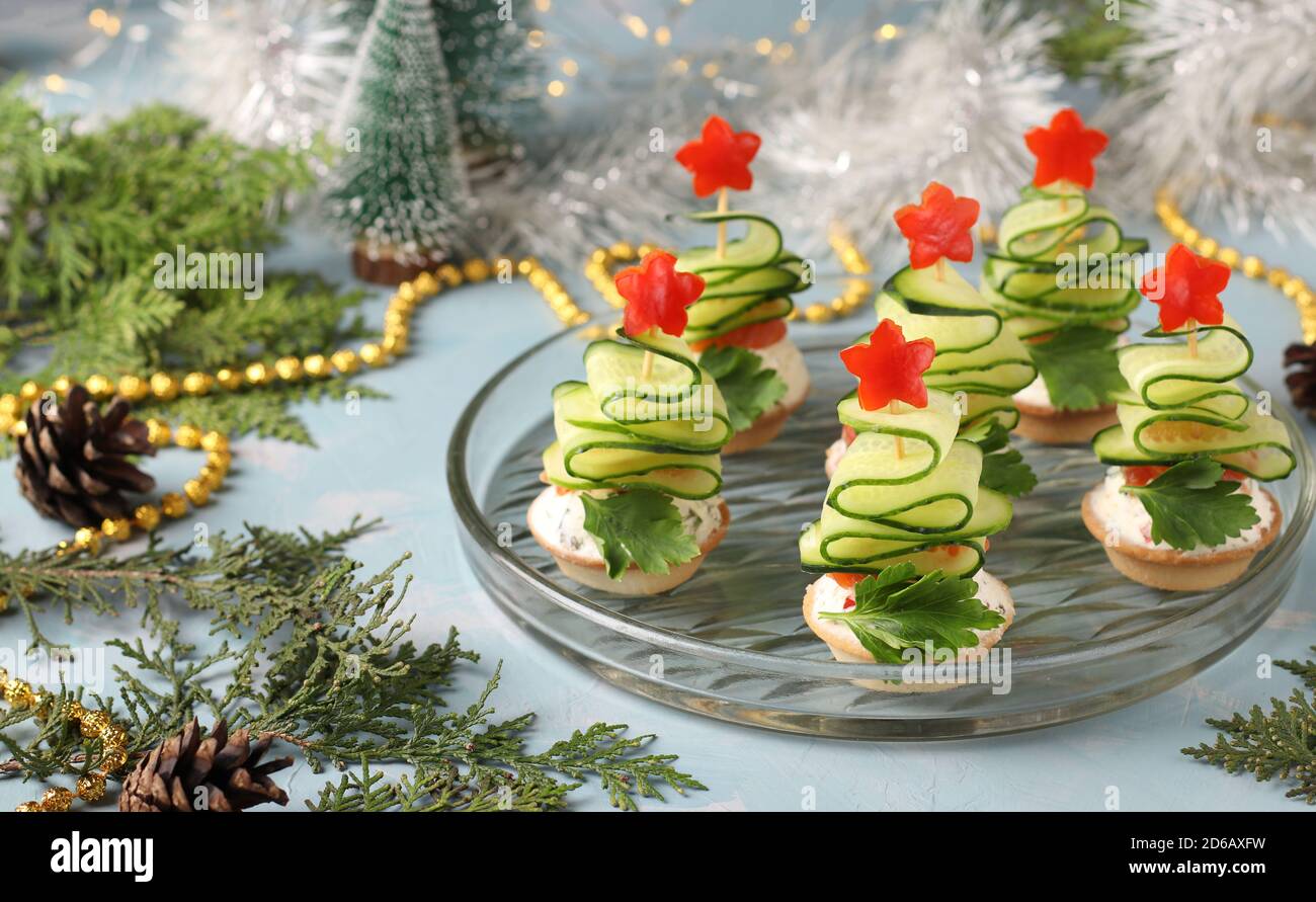 Festive canapes in shape of Christmas trees made of cucumbers and stars ...