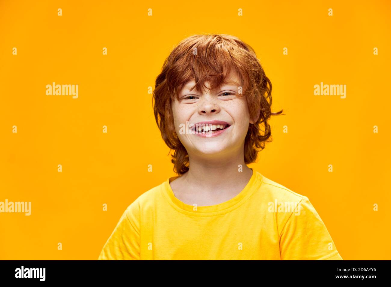 Funny redhead boy laughing on a yellow background in a T-shirt Stock ...