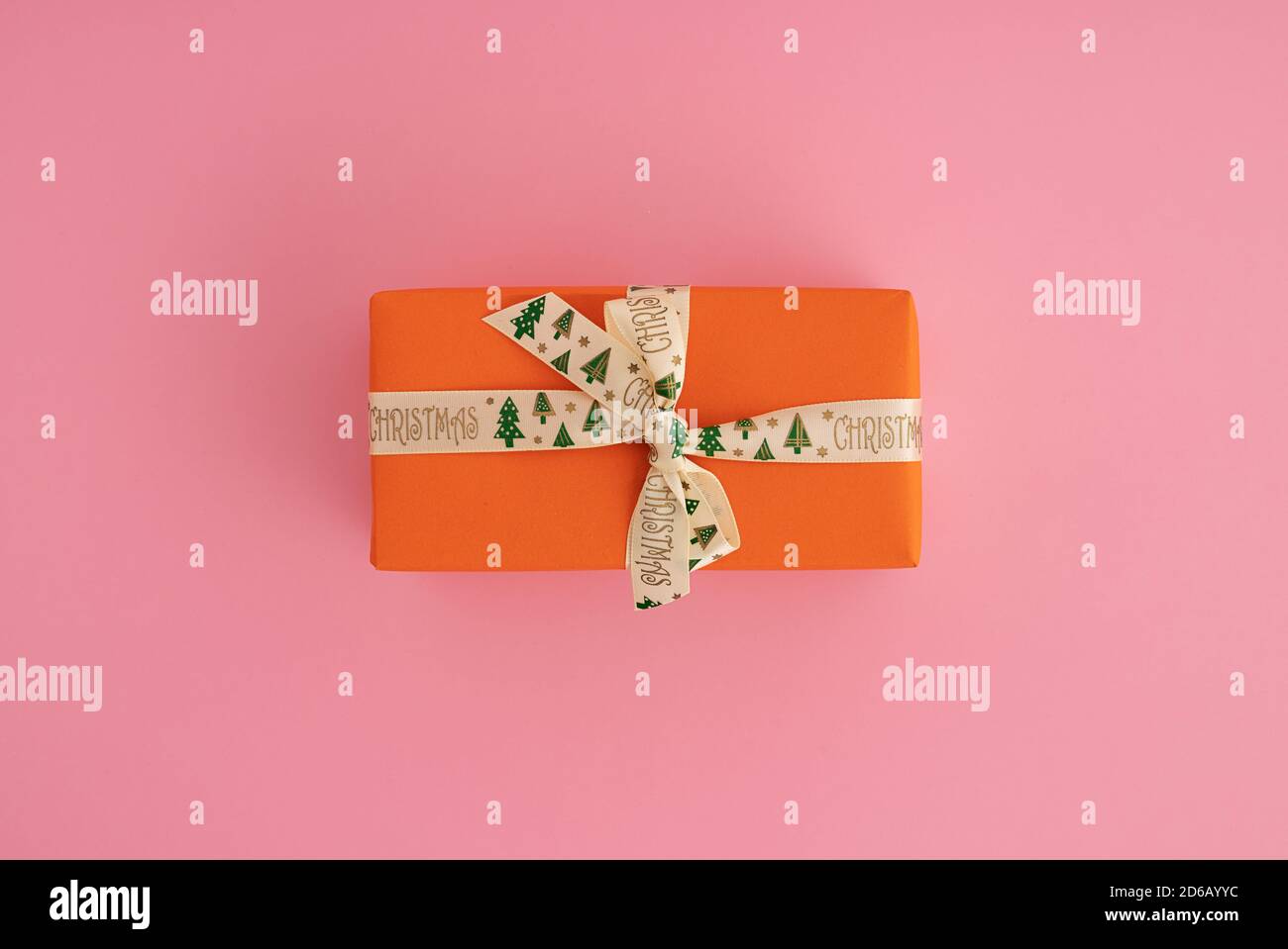Orange Christmas gift box in the pink background Stock Photo - Alamy
