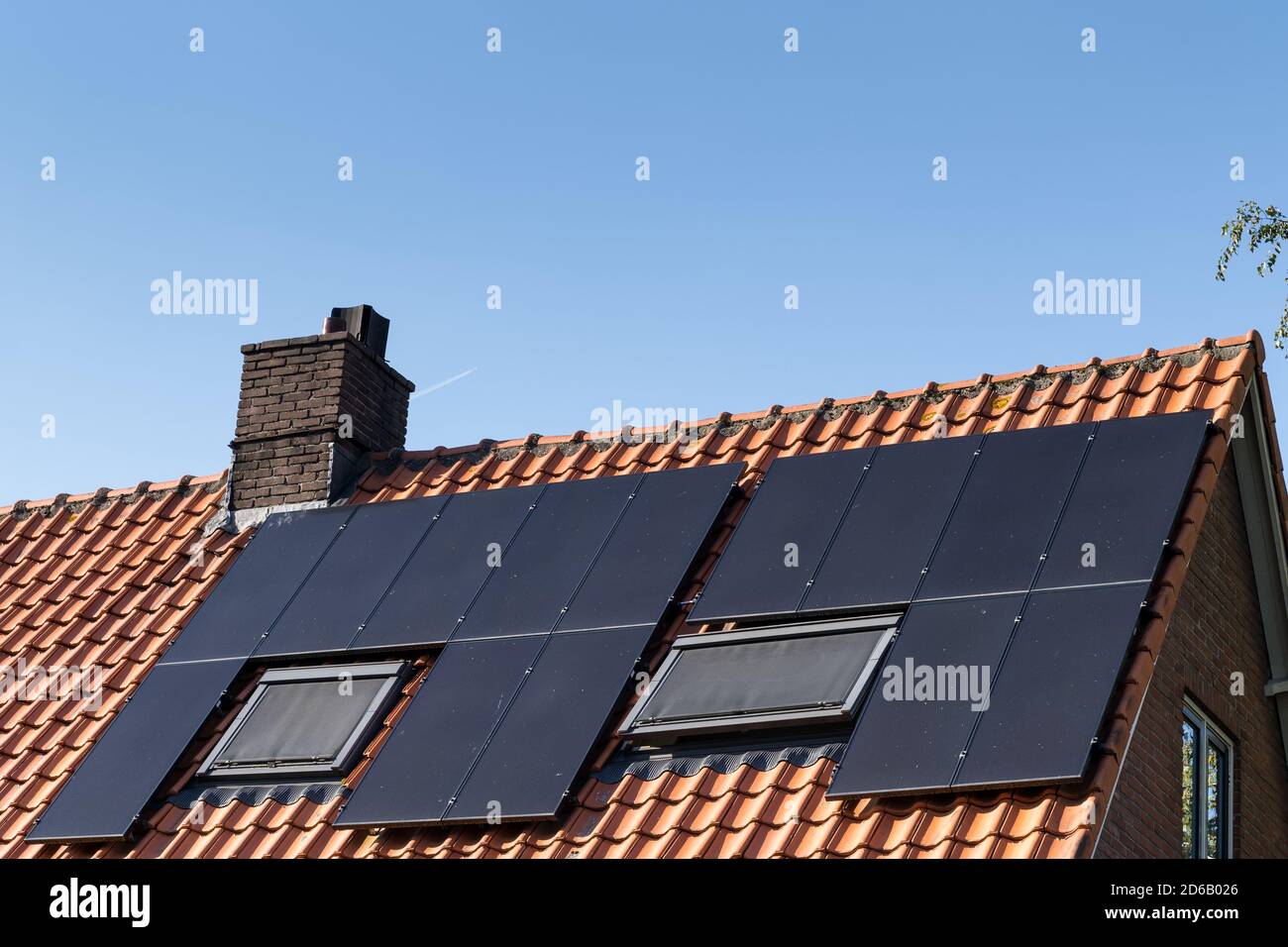 Roof with red roof tiles and solar panels for making renewable energy ...