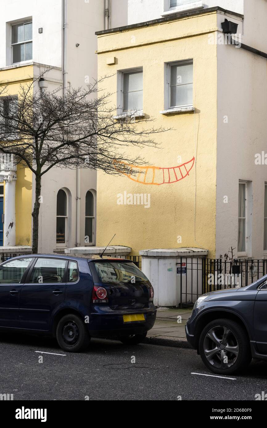 Yellow building with two windows and a smile drawn on the wall ...