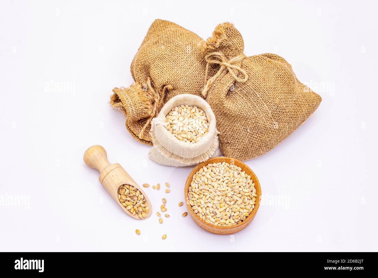 Whole peeled pearl barley grains isolated on white background. A ...