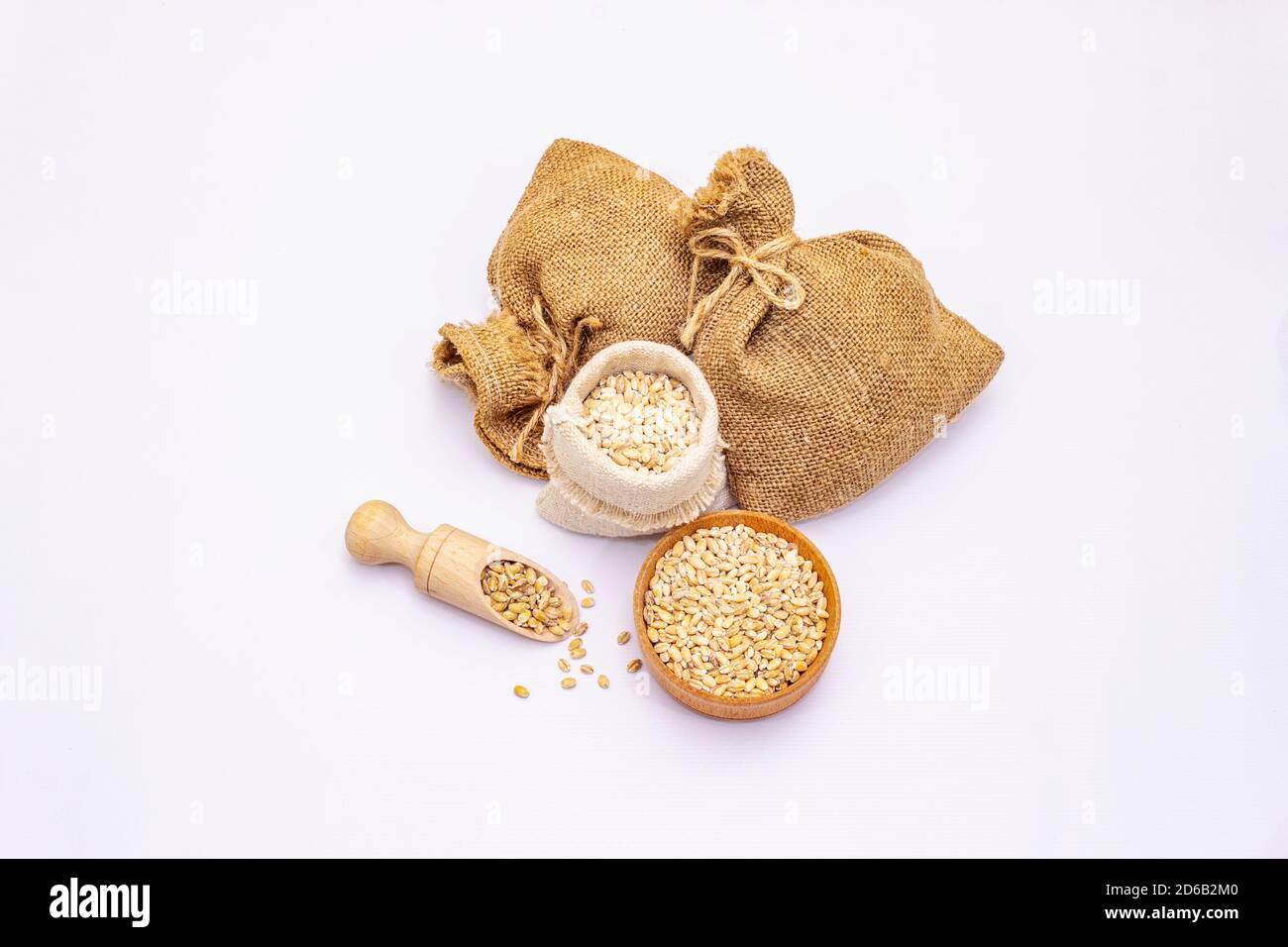 Whole peeled pearl barley grains isolated on white background. A ...