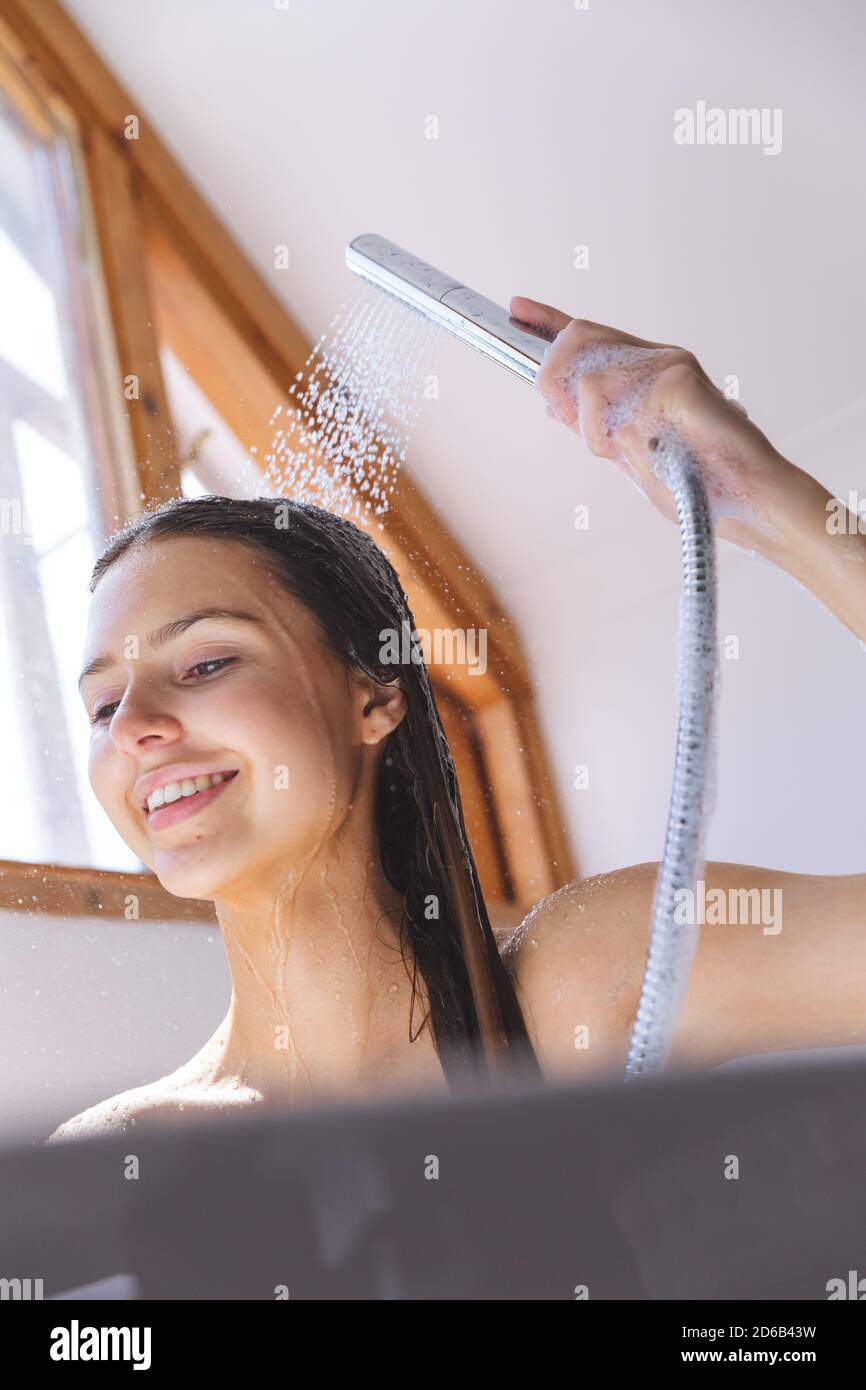 Woman showering in bathtub in bathroom Stock Photo - Alamy