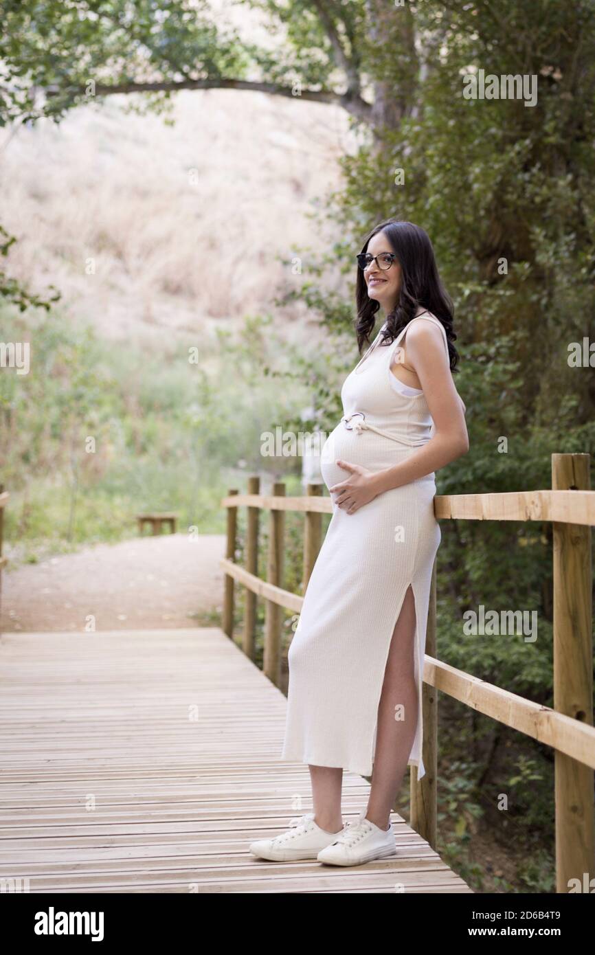 Cheerful Caucasian woman on maternity shoot in a wooden bridge Stock ...
