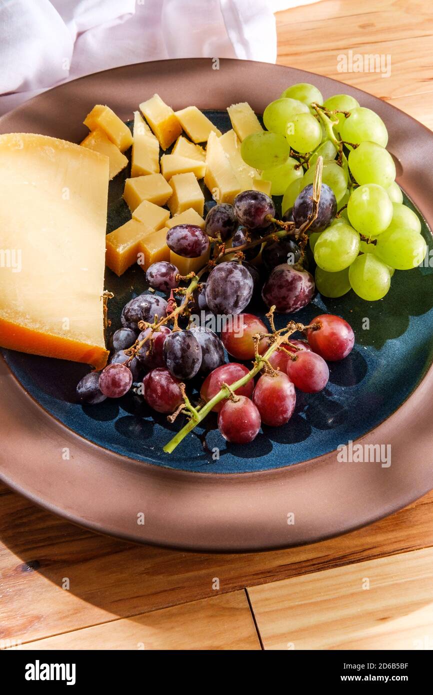 Gouda cheese fancy gourmet snack plate with tri-color grapes Stock ...
