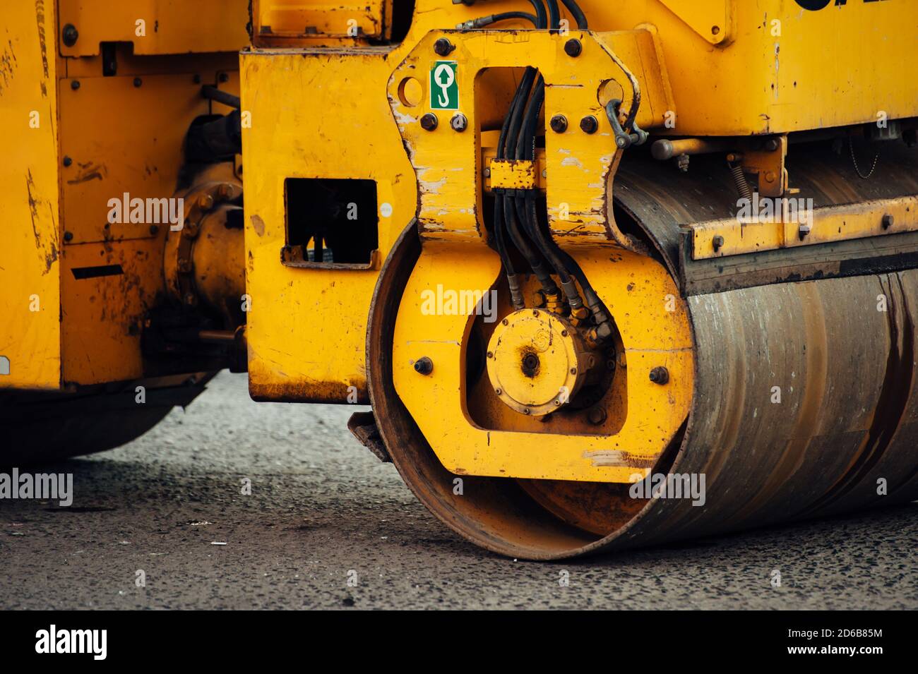A yellow asphalt compactor aligns the road. Laying new asphalt Stock ...