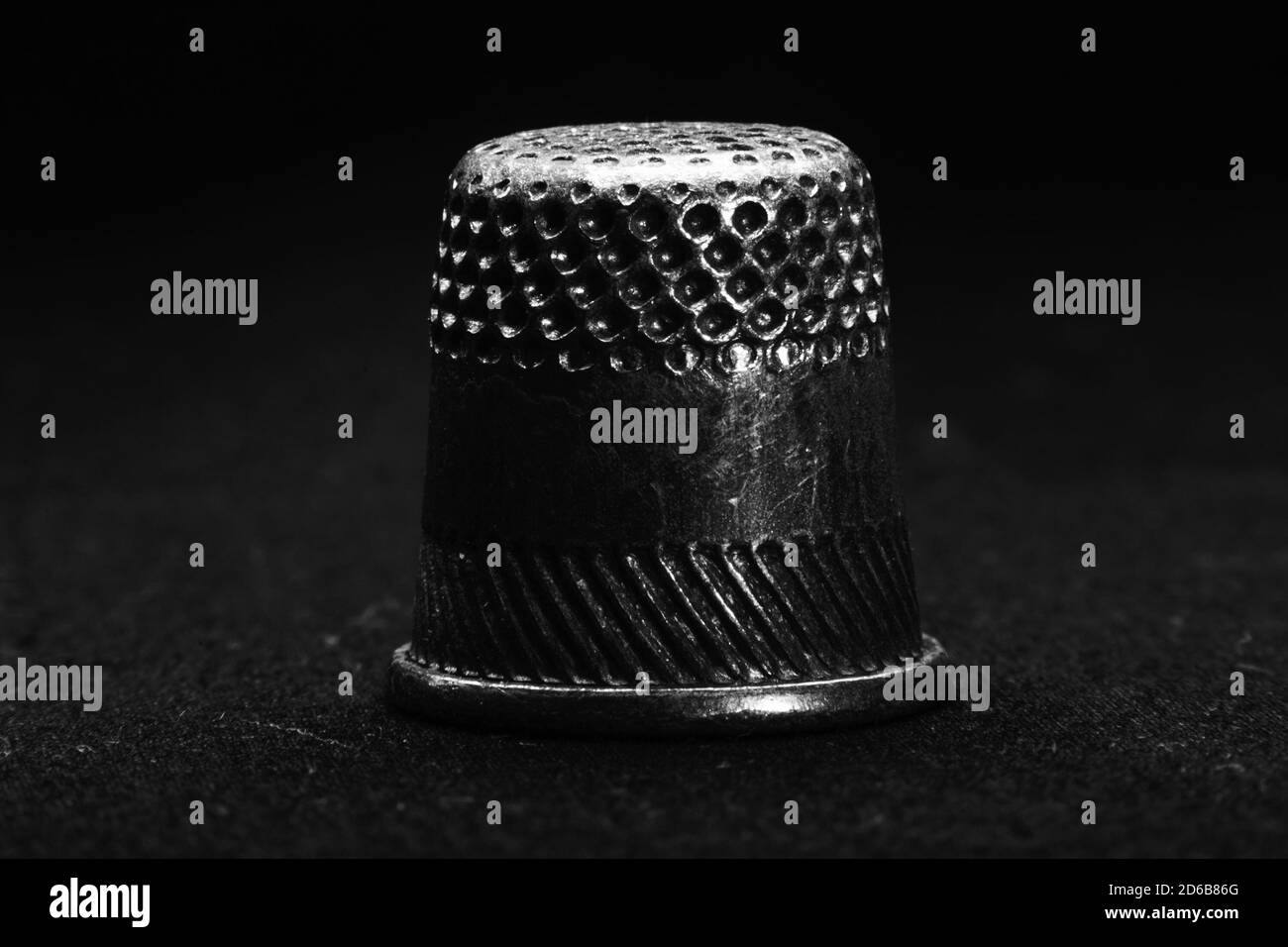 A small thimble closeup on a black background. Backlight Stock Photo ...